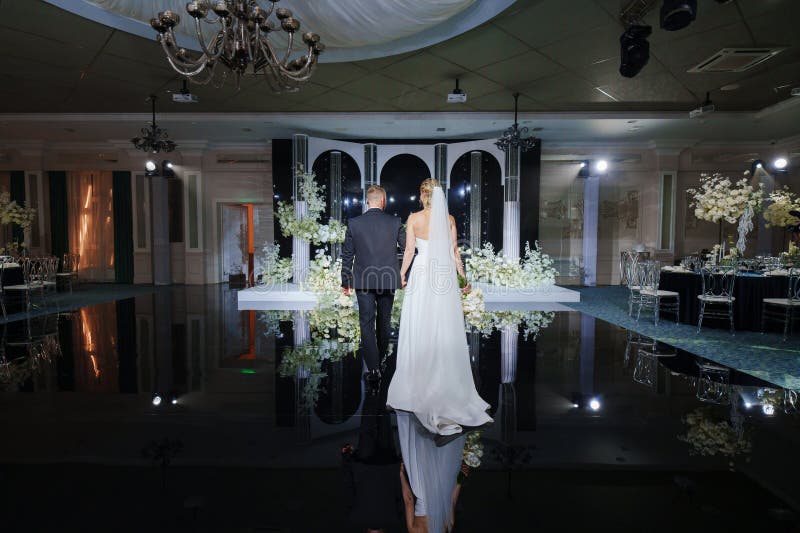 The Bride and Groom Walk through the Banquet Hall To Their Table. Stock ...