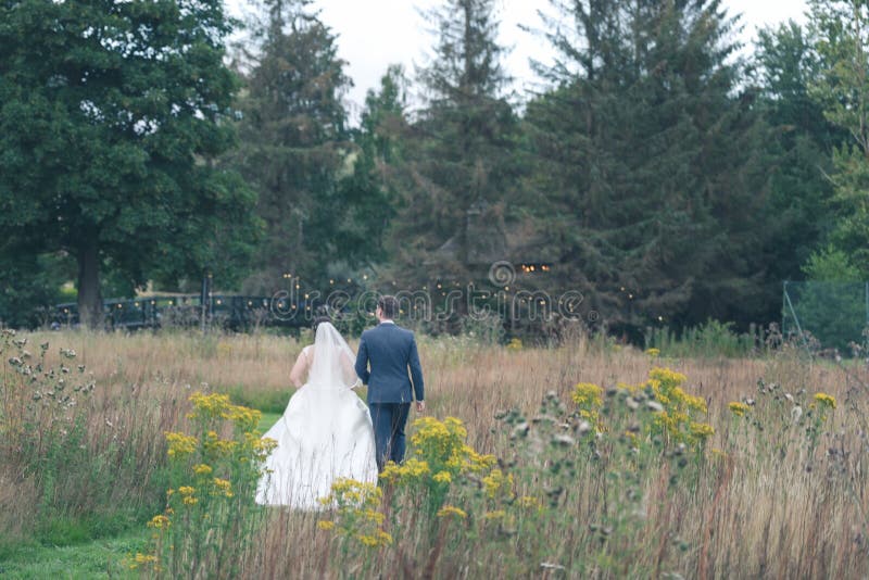 Bride and Groom Walking in the Garden Stock Photo - Image of walking ...