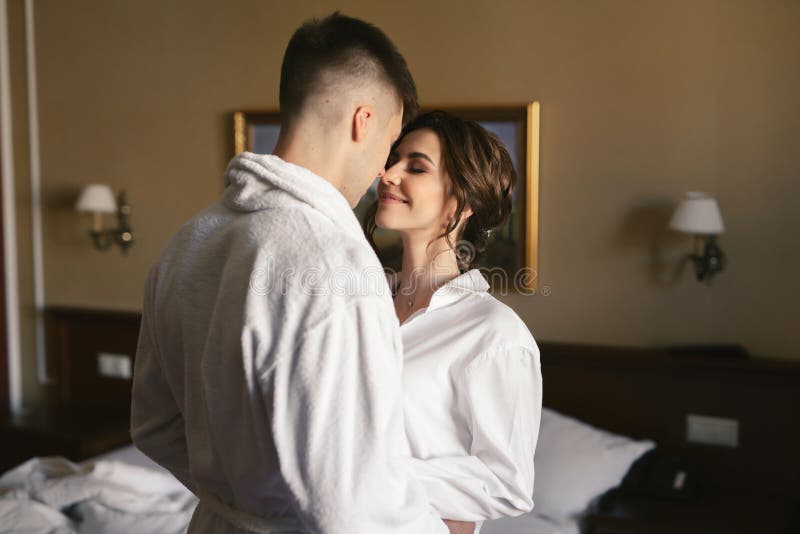 The Bride and Groom in White Coats Hug and Laugh in a Hotel Room Stock ...
