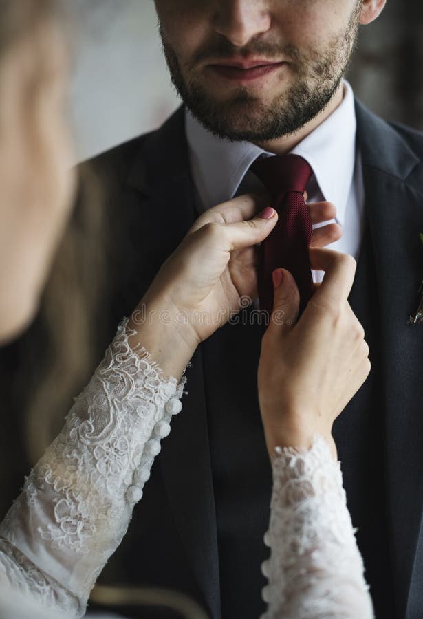 Bride Helping Groom Dressing Up for Wedding Ceremony Stock Photo ...