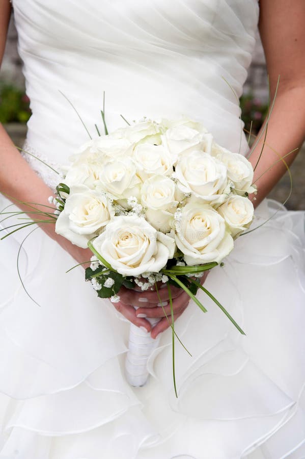 A Bride Holding a Bouquebride in a White Dress Holding a Bouquet of ...