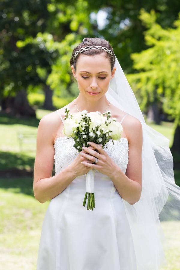 Bride Holding Flower Bouquet in Garden Stock Photo - Image of looking ...