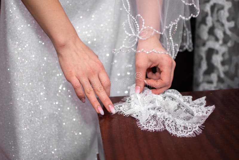 The Bride is Holding a Wedding Garter in Her Hands. Stock Photo - Image ...