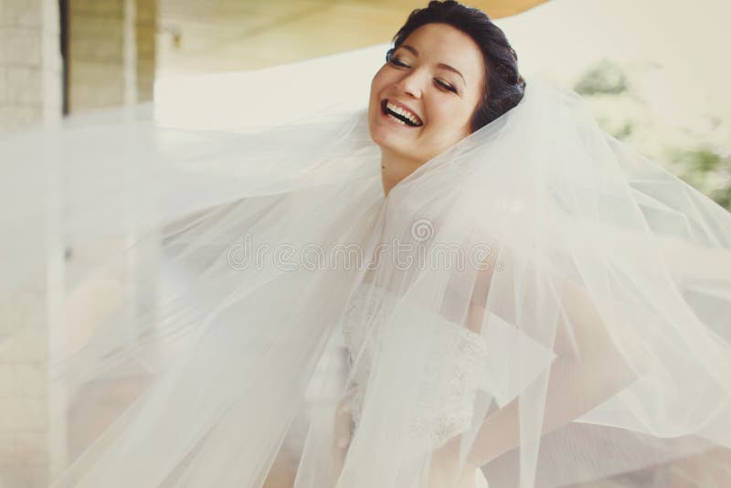 Bride Laughs while Wind Plays with Her Veil Stock Photo - Image of girl ...