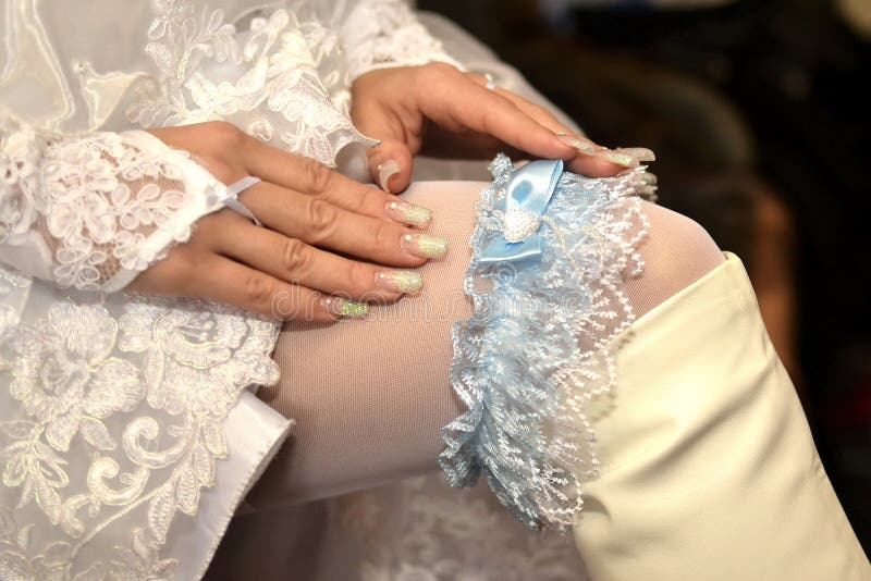 Bride Puts a Garter on Her Leg Stock Photo - Image of style, bridal ...