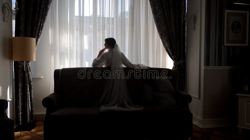 Bride Reflecting by the Window in a Softly Lit Room. a Bride Stands ...