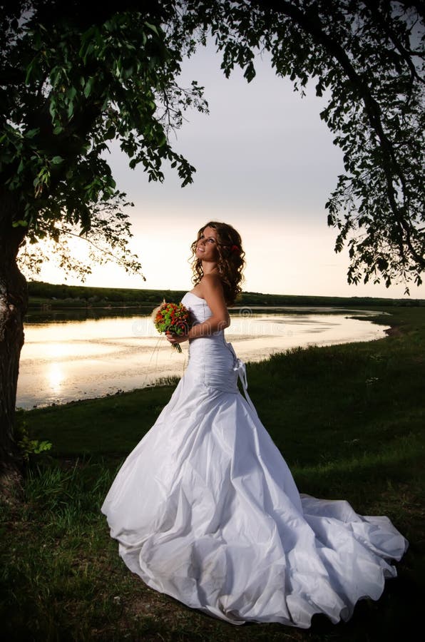 The Bride at the Riverside Under the Arch of Branches, Back View Stock ...