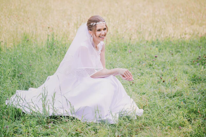 Bride sitting on the grass stock photo. Image of bridal - 166223432