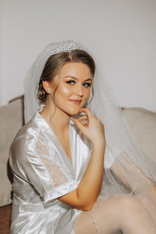 The Bride is Sitting on the Sofa in a Silk Dressing Gown. the Bride is ...