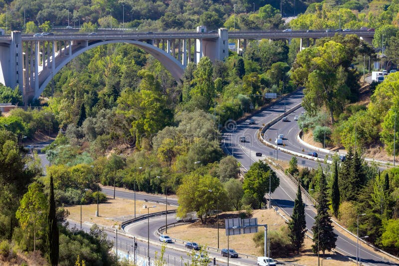 Bridge with Arch and Asphalt Road that Cuts a Path through the Forest ...