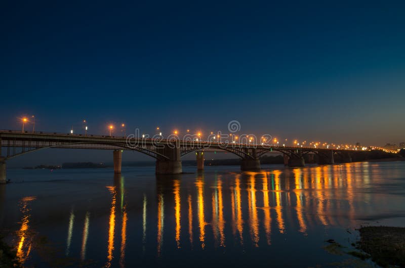 Bridge with Bright Lights Across the River at Night and Reflection ...