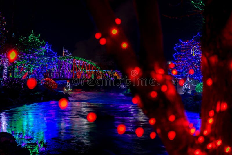 Bridge Covered with Christmas Lights Reflects in a River at Night Stock ...