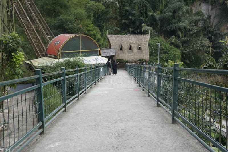 A Bridge Featuring a Small Building Atop it, Surrounded by a Serene ...