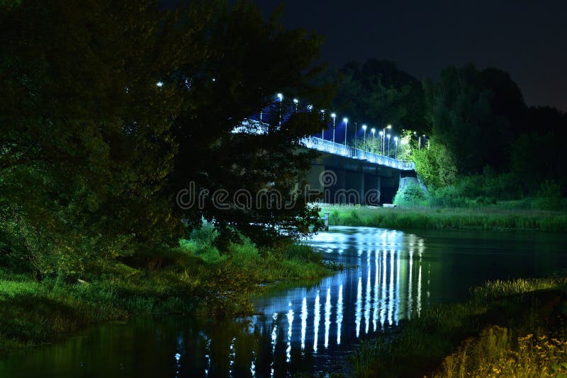 Bridge Illuminated by LED Lanterns at Dusk among Trees. River. Night ...