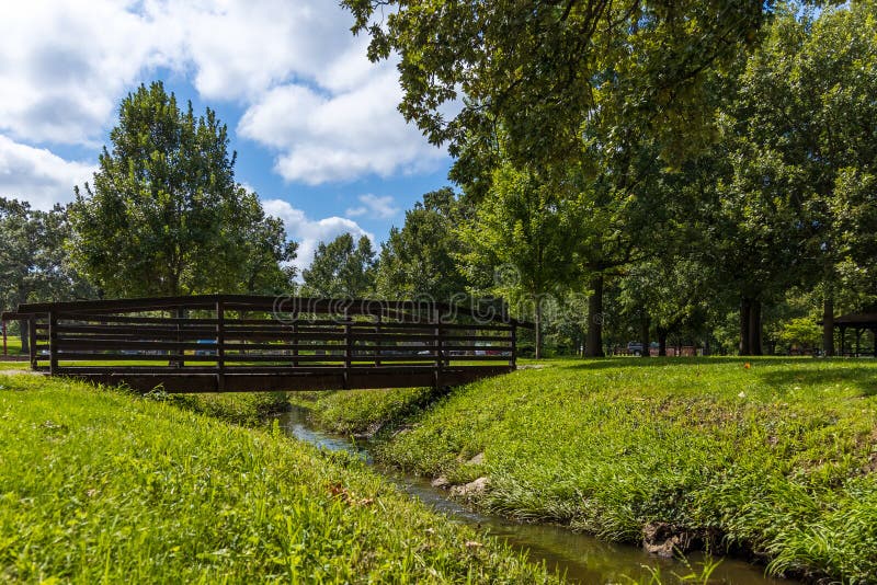 Bridge Over a Creek Running through a Park Stock Photo - Image of field ...
