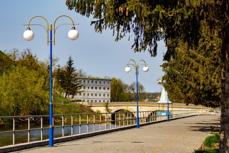 A Bridge Over a River Next To a Tree and Street Lights Stock Image ...