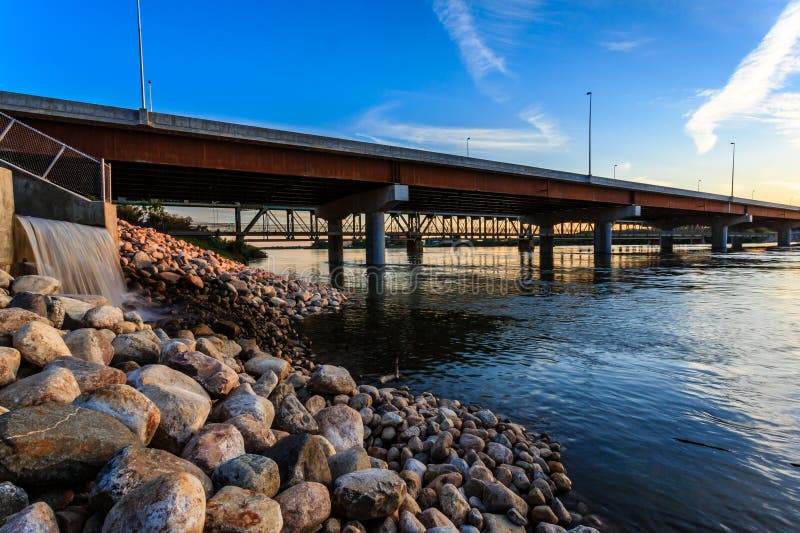 A Bridge Over a River with a Waterfall on the Side Stock Image - Image ...