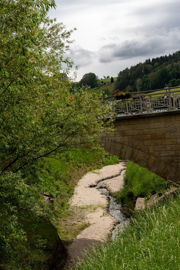 A Bridge Over a Stream with a Tree in the Background Stock Image ...