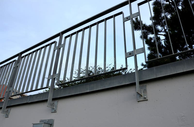 A Bridge Railing with Vertical Fence Posts Anchored into the Ground ...