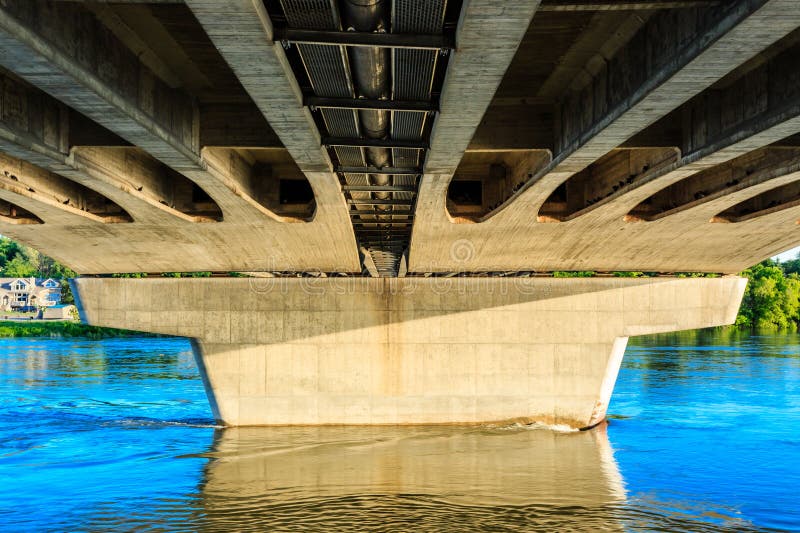 A Bridge is Shown from the Underside, with the Water Below and the Sky ...
