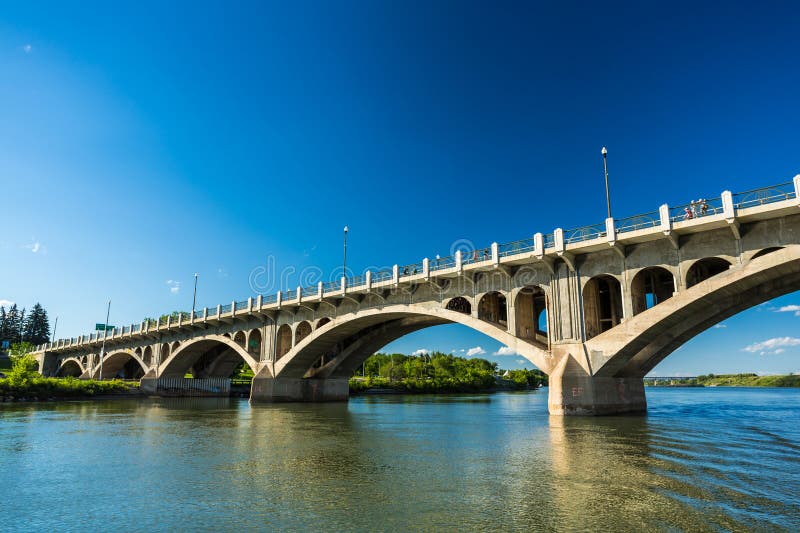 A Bridge Spans a River, with a Clear Blue Sky Above Stock Photo - Image ...