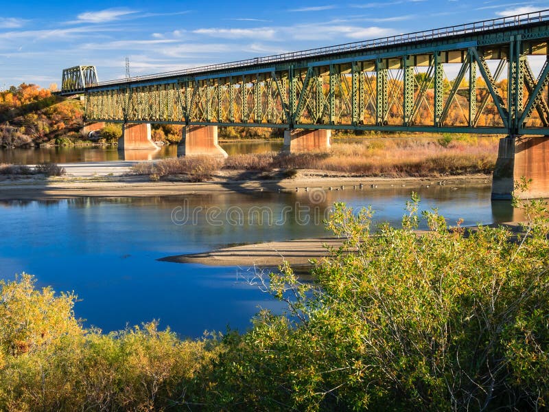 A Bridge Spans a River with a Green Bridge in the Background Stock ...
