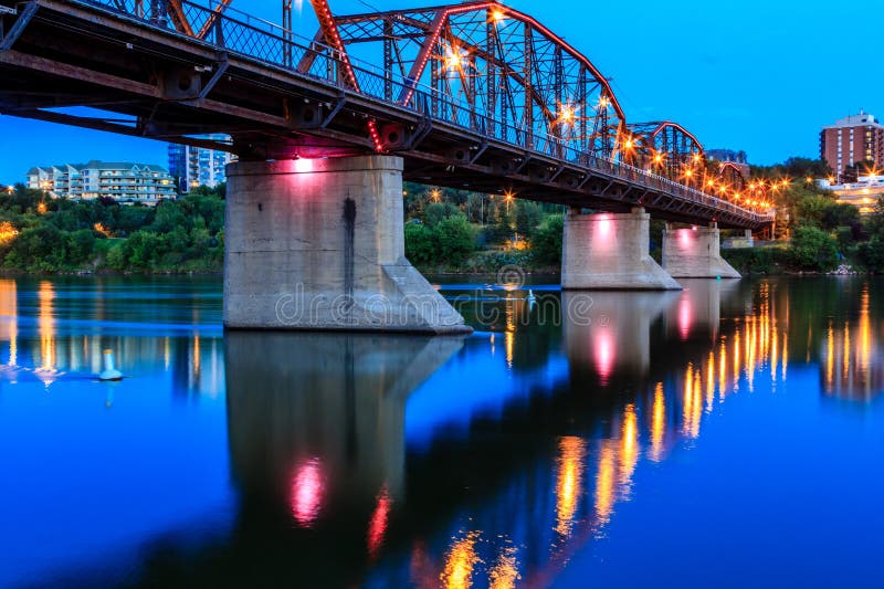 A Bridge Spans a River at Night, with Lights Illuminating the Structure ...
