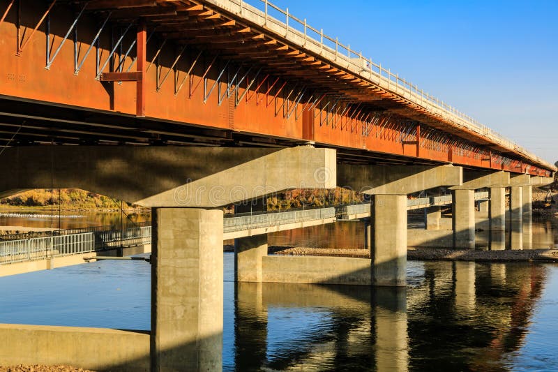 A Bridge Spans a River with a Reflection of the Bridge in the Water ...