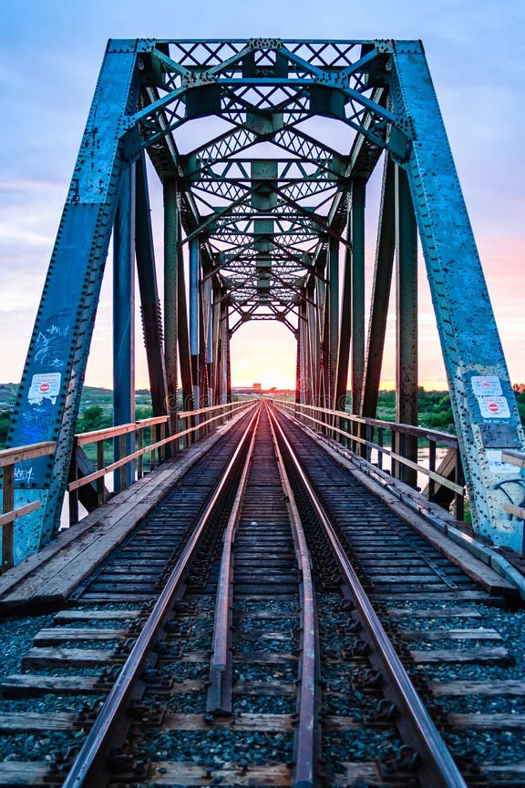 A Bridge with Train Tracks and a Sunset in the Background Stock Photo ...
