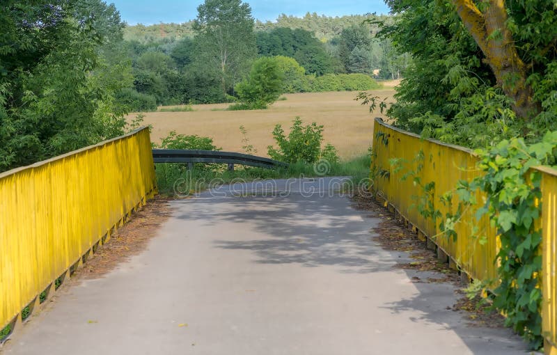A Bridge with Yellow Steel Railings among Forests and Fields. Stock ...