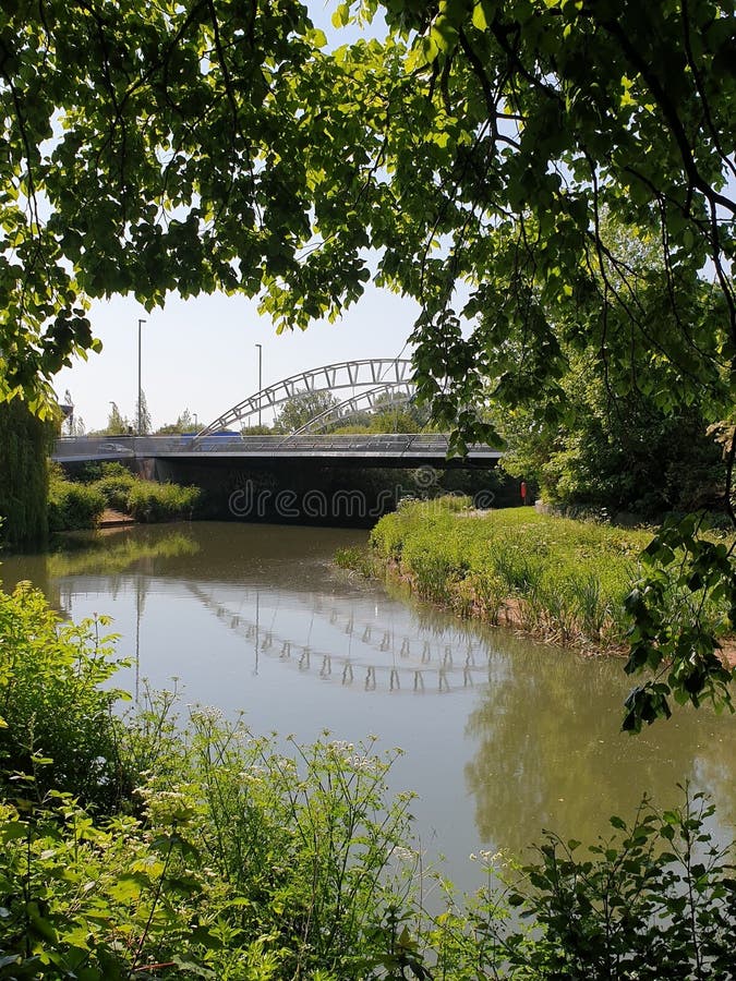 A Bridges Reflection Onto a River Stock Image - Image of water, river ...