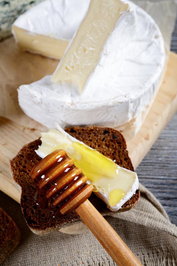 Brie Cheese, Rye Bread Slice, Honey and Dipper on a Board Stock Image ...