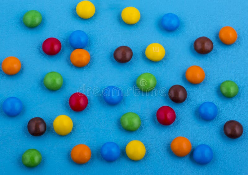 Bright Background Made of Colored Chocolate Candy on a Blue Background ...