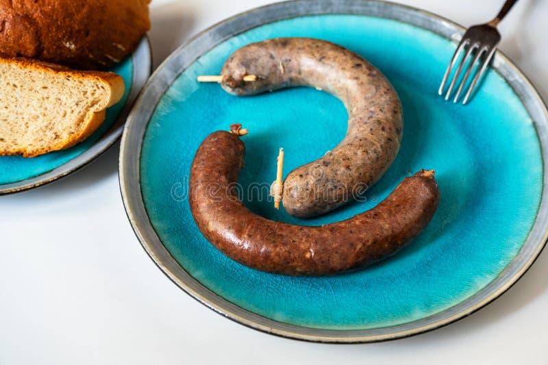 Bright and Black Pudding Sausage on Blue Plate, Fork, Bread on White ...