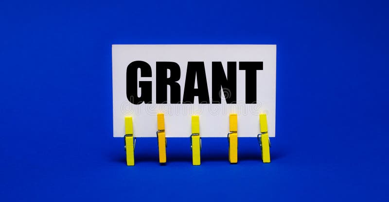 On a Bright Blue Background on Yellow Clothespins, a White Card with ...