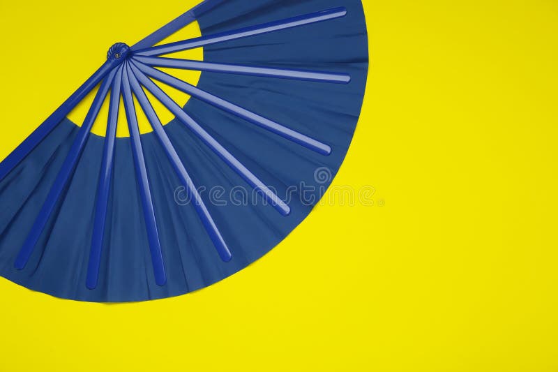 Bright Blue Hand Fan on Yellow Background, Top View. Space for Text ... Bright Blue Hand Fan on Yellow Background, Top View. Space for Text ...