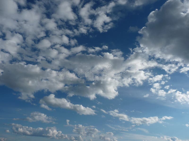 Bright Blue Sky Filled with Fluffy White Clouds. Sunlight Peeks through ...