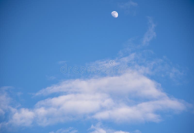 A Bright Blue Sky with Thick White Clouds and a White Moon Stock Image ...