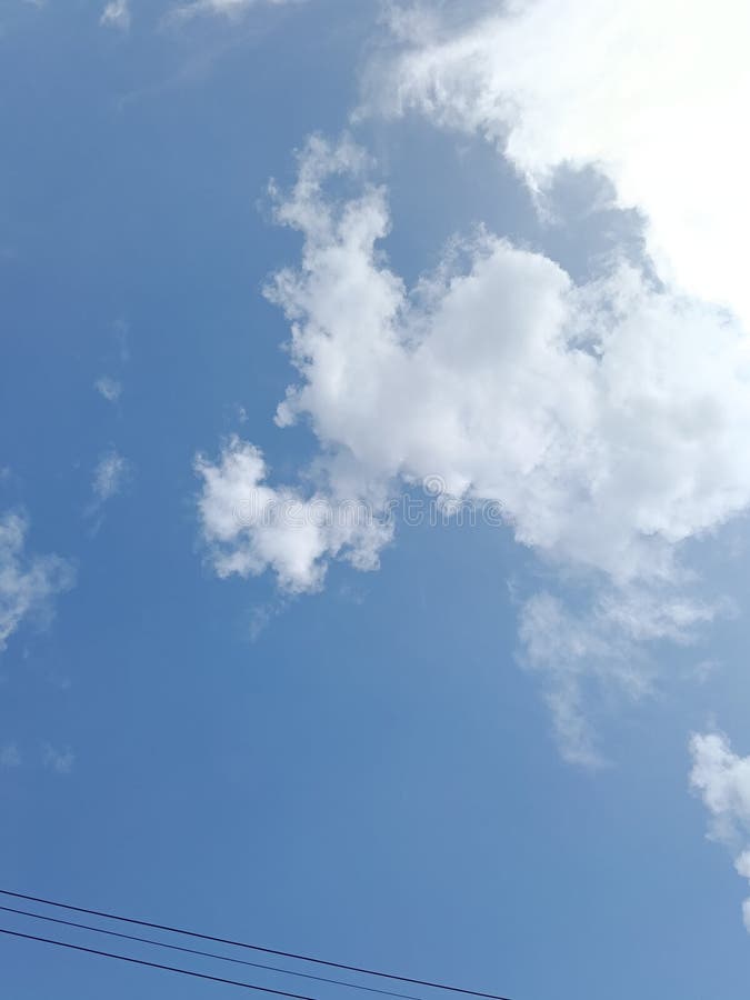 A Bright Blue Sky with Wispy White Clouds, with Two Parallel Power ...