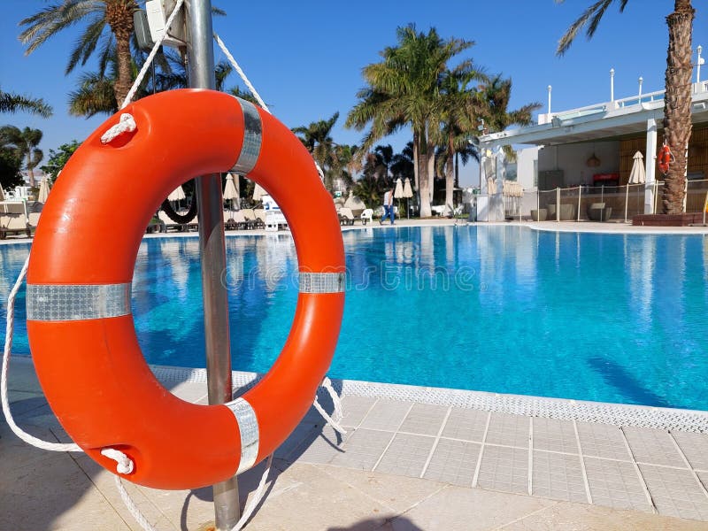 Bright-colored Life Ring Placed in Front of a Sun-drenched Swimming ...
