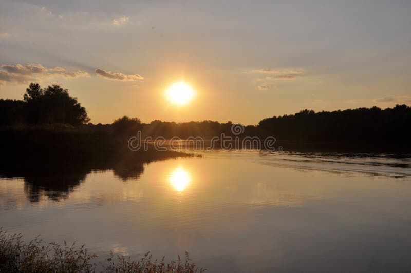Bright and Colorful Sunset on the River. the Sun Hides Behind the Trees ...