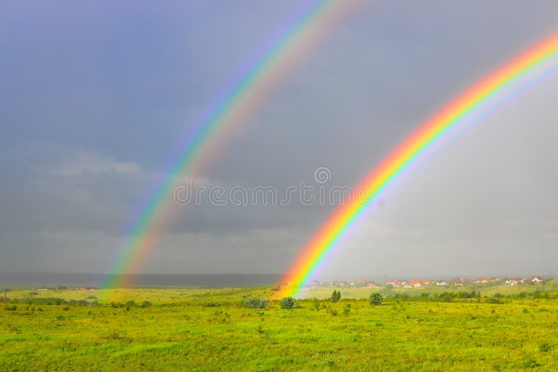 Bright Colors of Double Rainbow Rising from a Meadow with Dark Rain ... Bright Colors of Double Rainbow Rising from a Meadow with Dark Rain ...