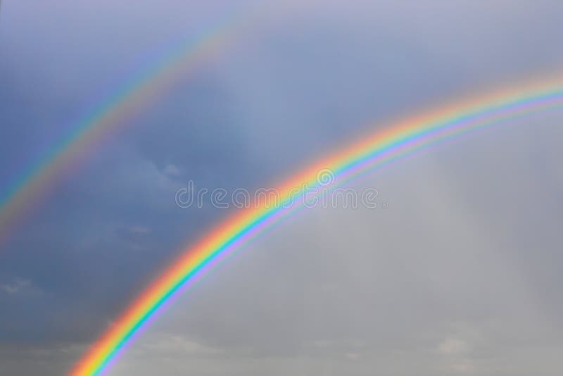 Bright Double Rainbow with Dark Rain Clouds in the Background Stock ... Bright Double Rainbow with Dark Rain Clouds in the Background Stock ...