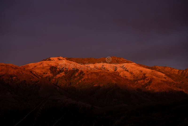 Bright Hill Side Highlighted Below Dark Purple Skies Stock Photo ...