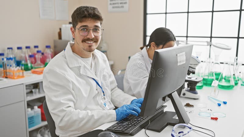 In a Bright Laboratory, a Woman and a Man in Lab Coats Work on a ...
