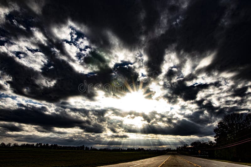 Bright Light Beaming through Clouds Dim Light on a Rural Road in the ...