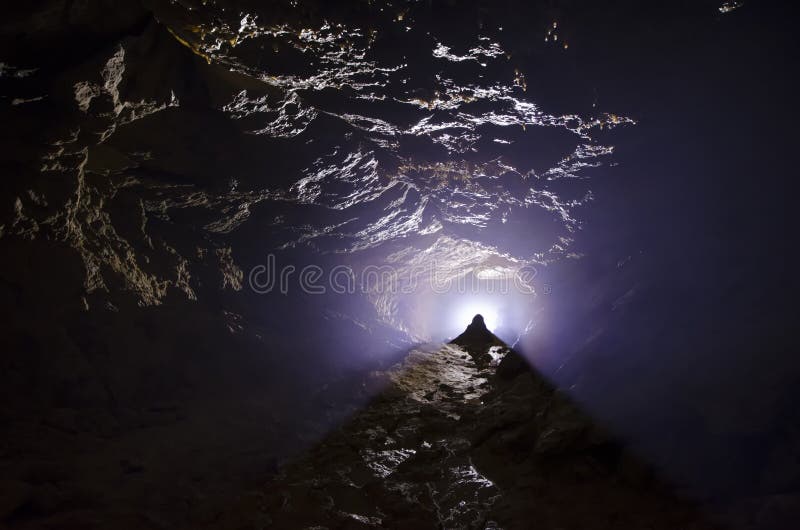 Bright Light in a Dark Cave Stock Image - Image of speleology, geology ...
