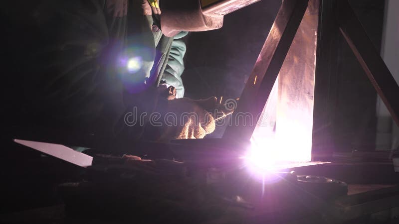 Bright Light and Sparks from Welding. Industrial Worker in a Protective ...