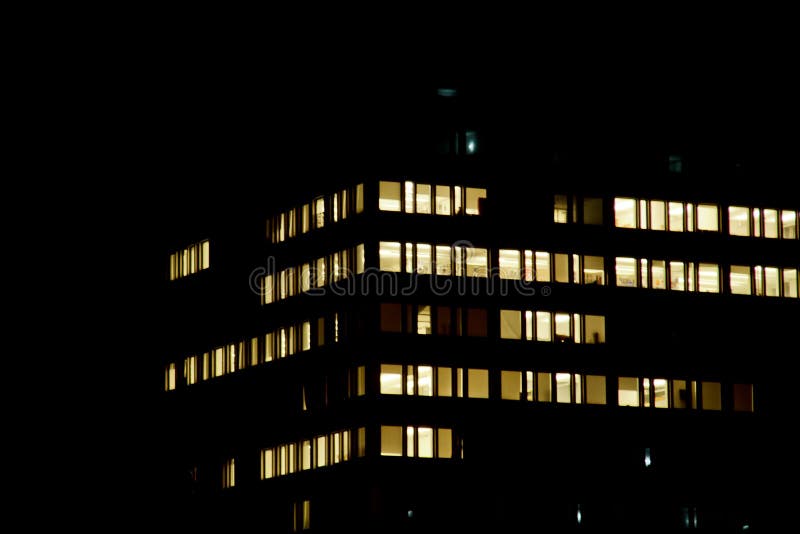 Bright Light in the Square Windows of a Multistory Building at Night in ...