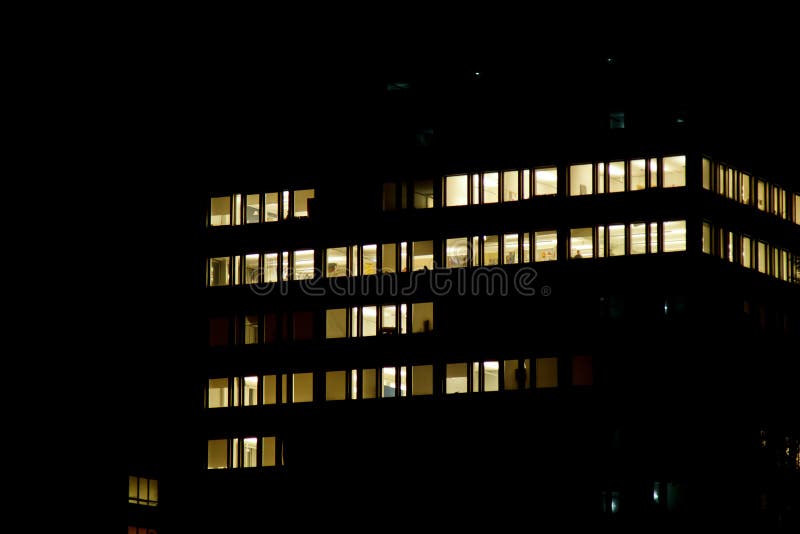 Bright Light in the Square Windows of a Multistory Building at Night in ...